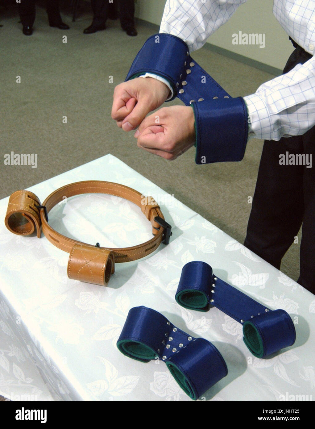 TOKYO, Japan - A Justice Ministry official shows off a new restraining ...