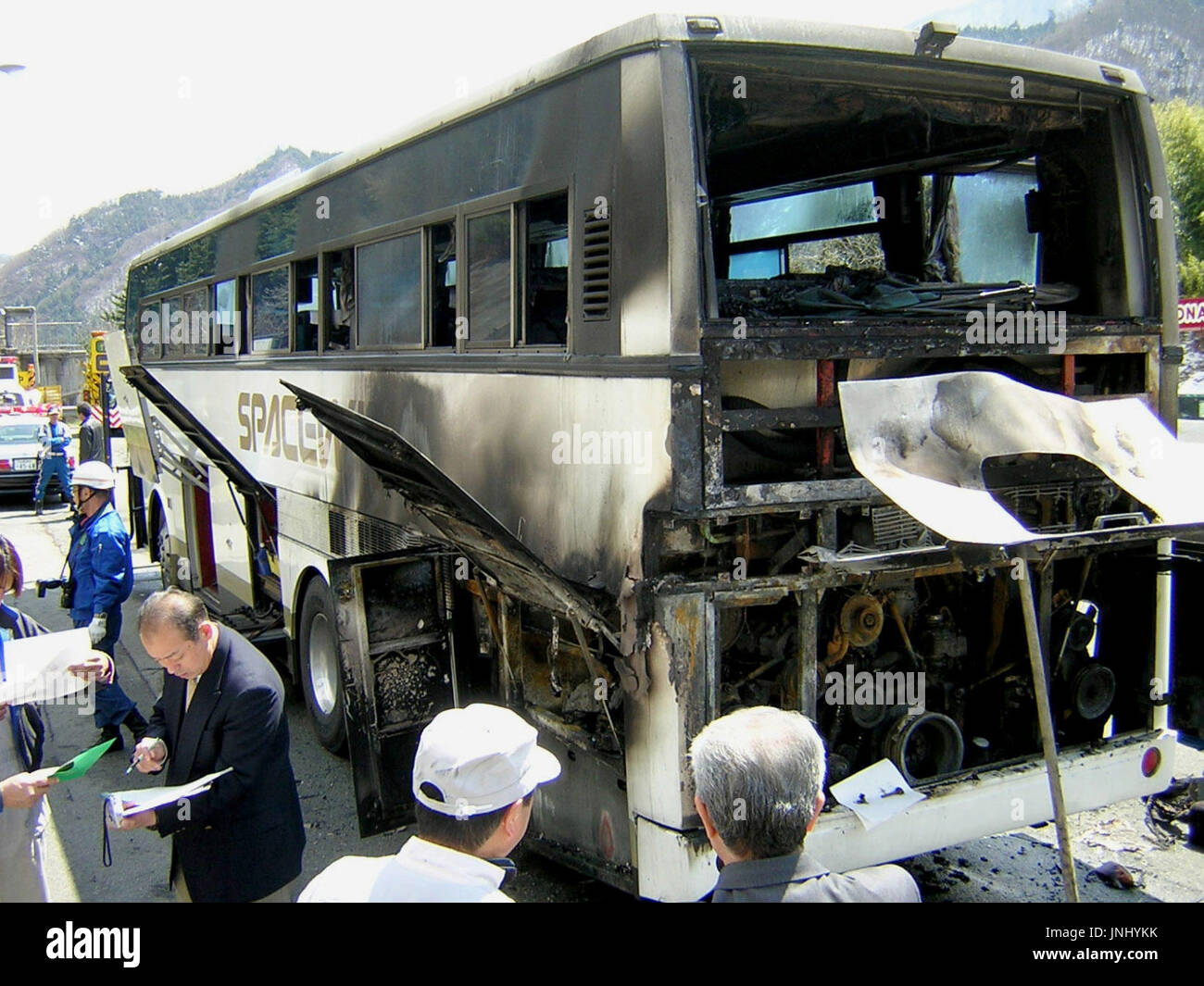 OTSUKI, Japan - Police officers examine a burnt sightseeing bus April 5 ...