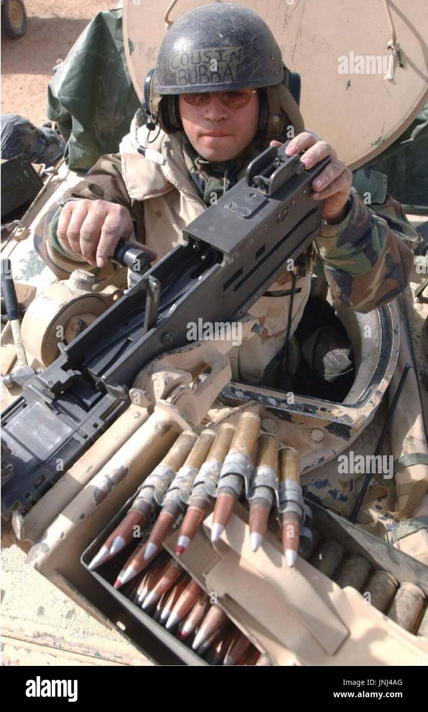 NAJAF, Iraq - A U.S. solder prepares a machine gun on an armored ...