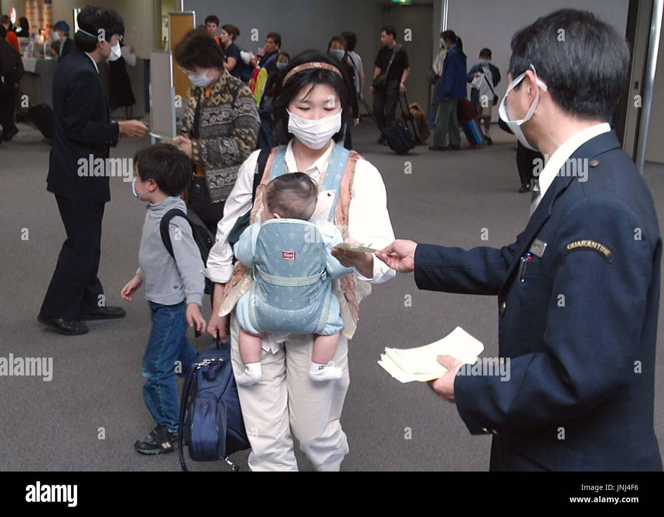 NARITA, Japan - An airport official hands a leaflet on a new pneumonia ...