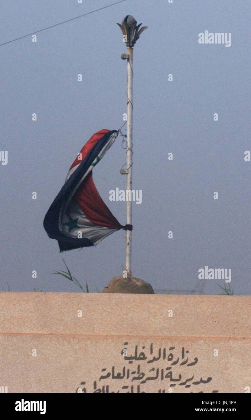 BAGHDAD, Iraq - An Iraqi flag is seen partly burnt on a building in ...