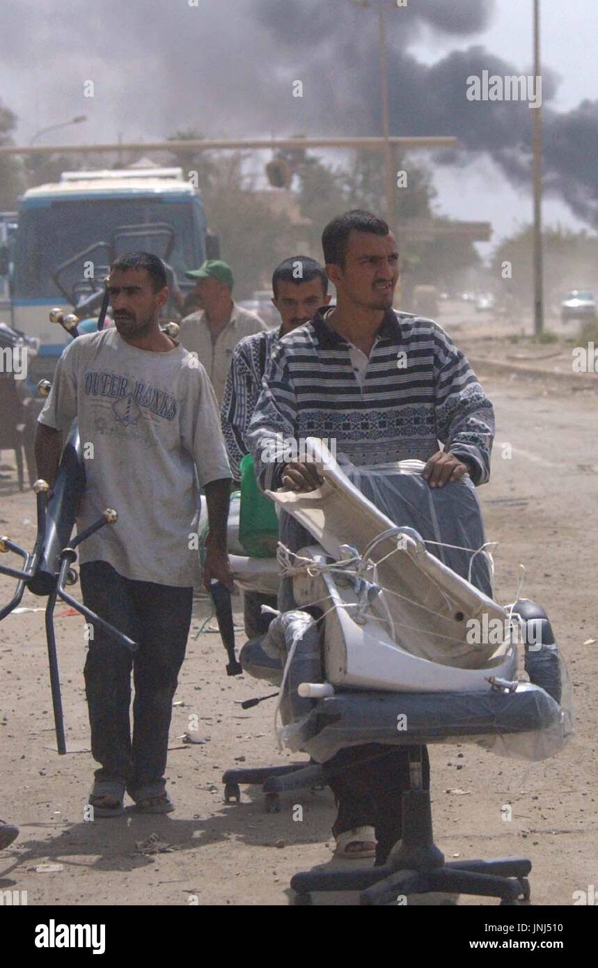 BAGHDAD, Iraq - Iraqi men carry furniture they found in one of ...