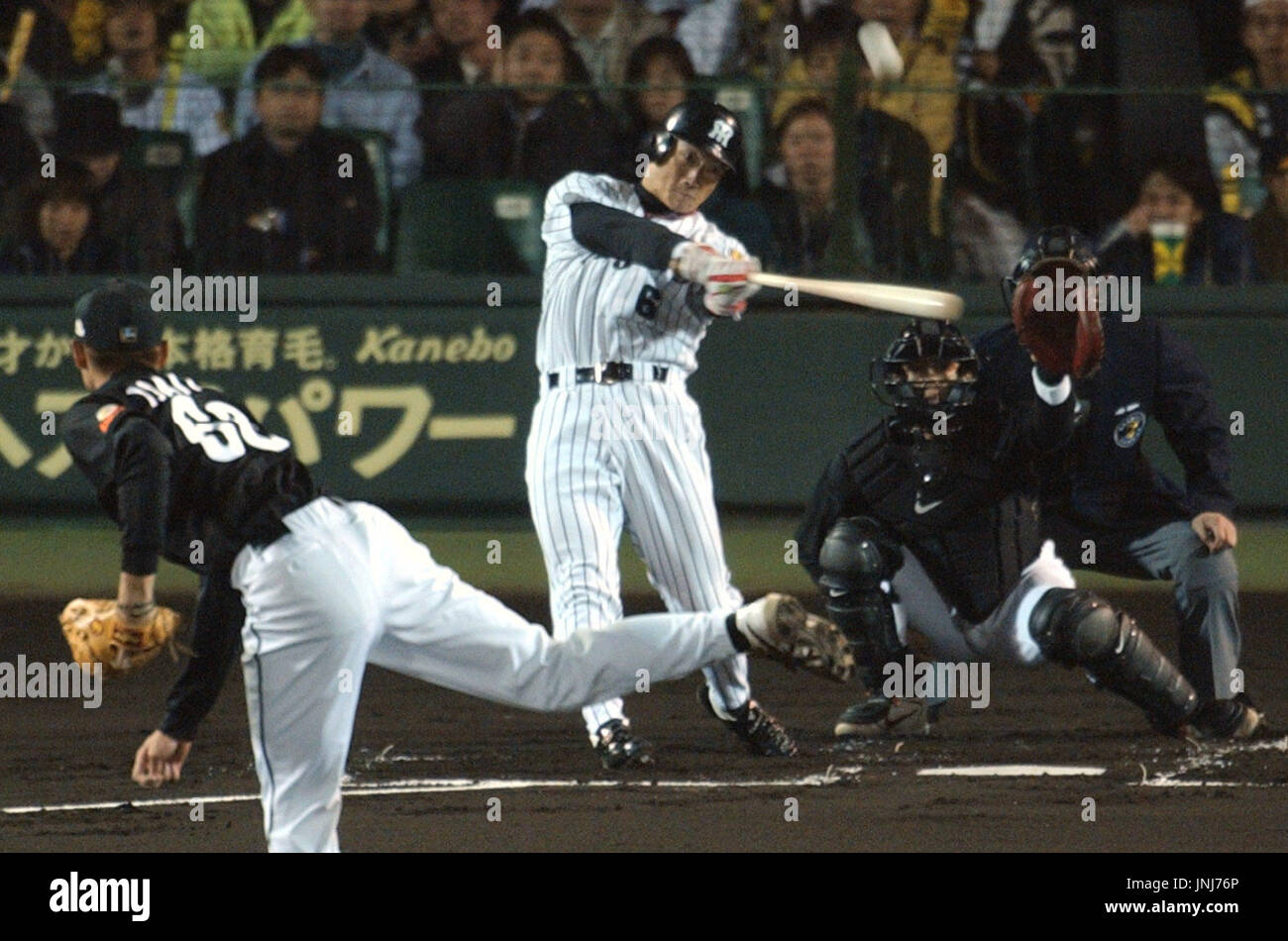 Koshien, Japan - Hanshin Tigers outfielder Tomoaki Kanemoto hits a solo homer off Daiei Hawks ...