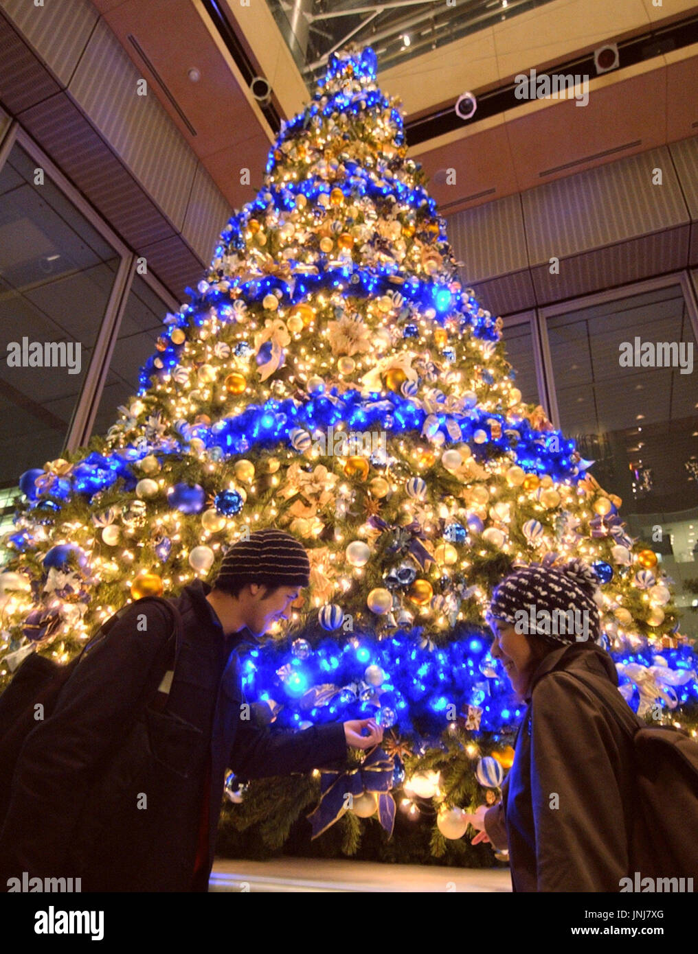 TOKYO, Japan - A couple look at an 8-meter Christmas tree set up in the ...
