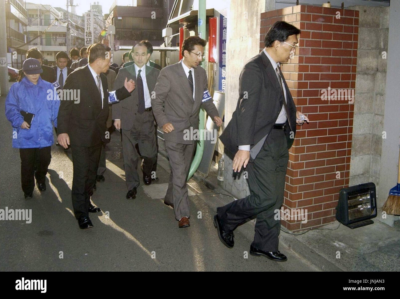 TOKYO, Japan - Public Security Intelligence Agency officials approach a ...