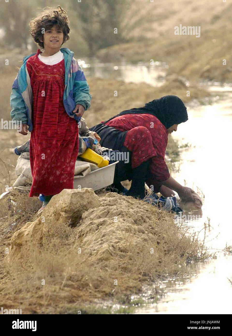 SAMAWAH, Iraq - An Iraqi girl poses for a photograph as her mother ...