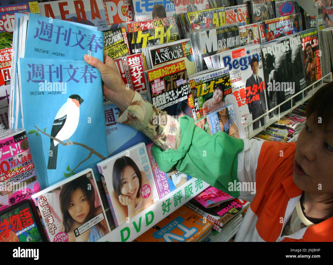 TOKYO, Japan - A woman holds up copies of weekly magazine Shukan ...