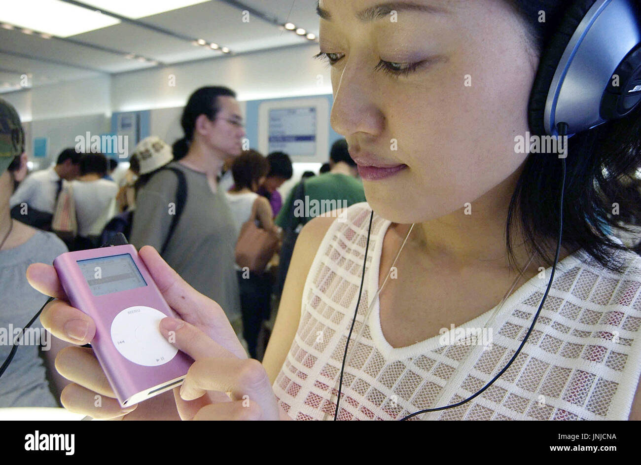 TOKYO, Japan - A customer listens to music on Apple Computer Inc.'s ...
