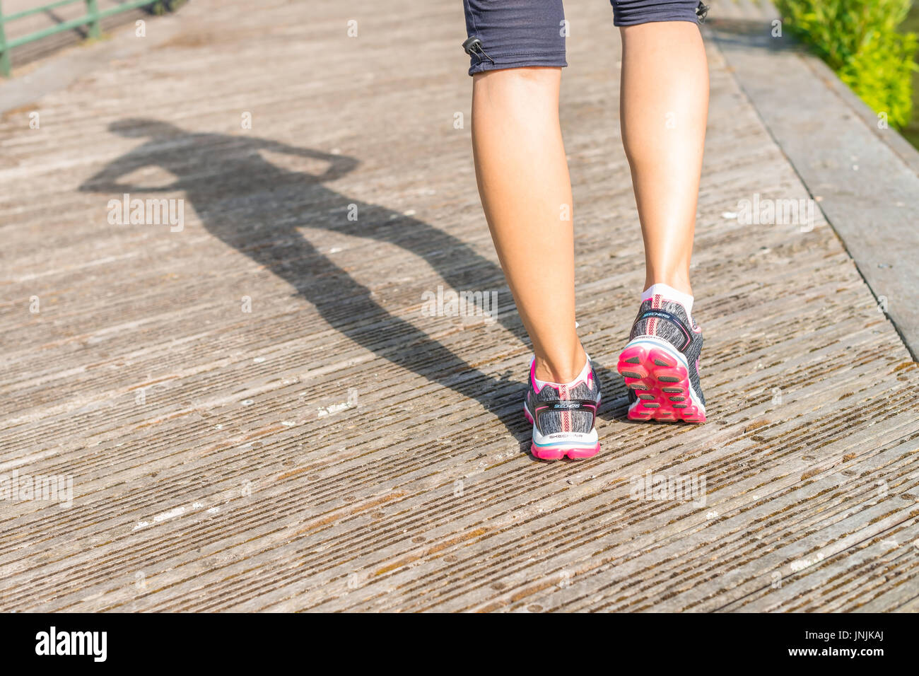 Woman runner shadow on the decks Stock Photo - Alamy