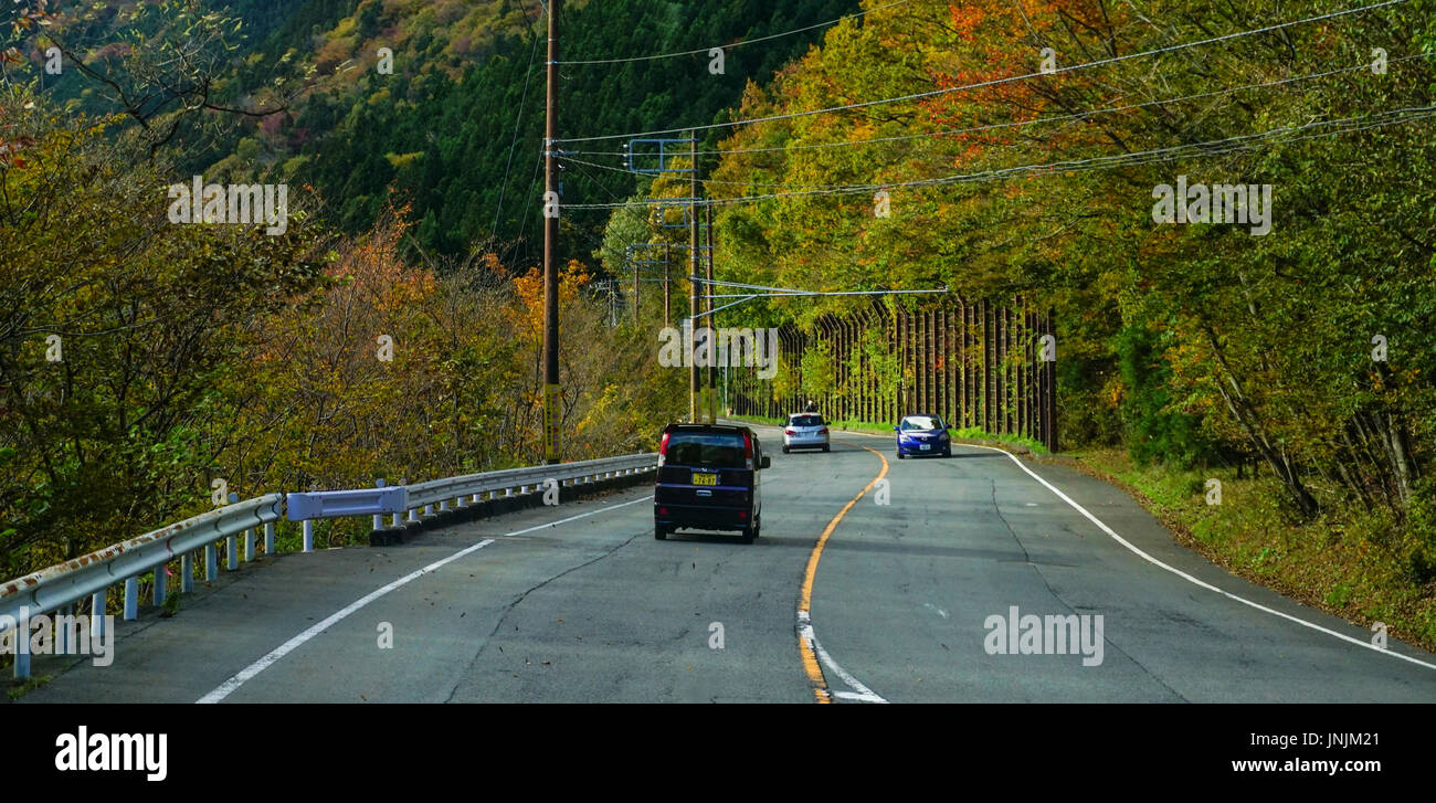 Nikko, Japan - Nov 3, 2014. Cars run on mountain road with many trees ...