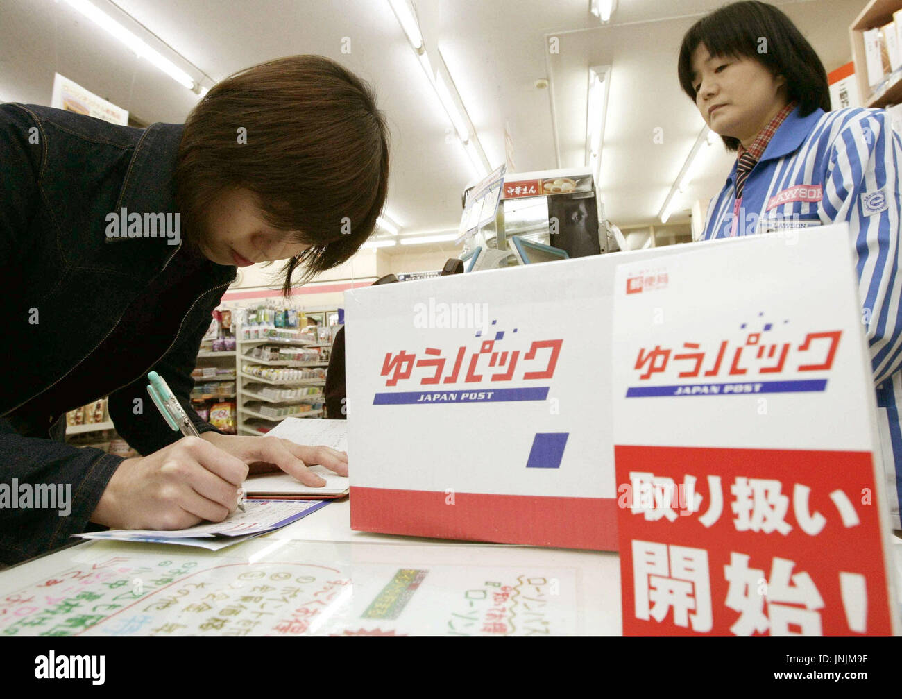 TOKYO, Japan - A customer fills out a form to send a parcel by Japan ...