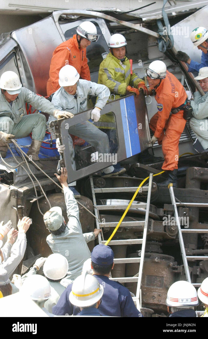 AMAGASAKI, Japan - Firefighters take off a train door during rescue operations at a site where ...