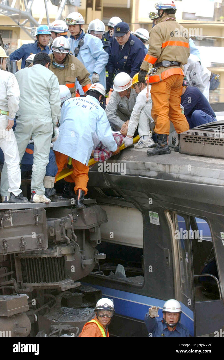 AMAGASAKI, Japan - Firefighters rescue injured passengers from the roof of a train that derailed ...