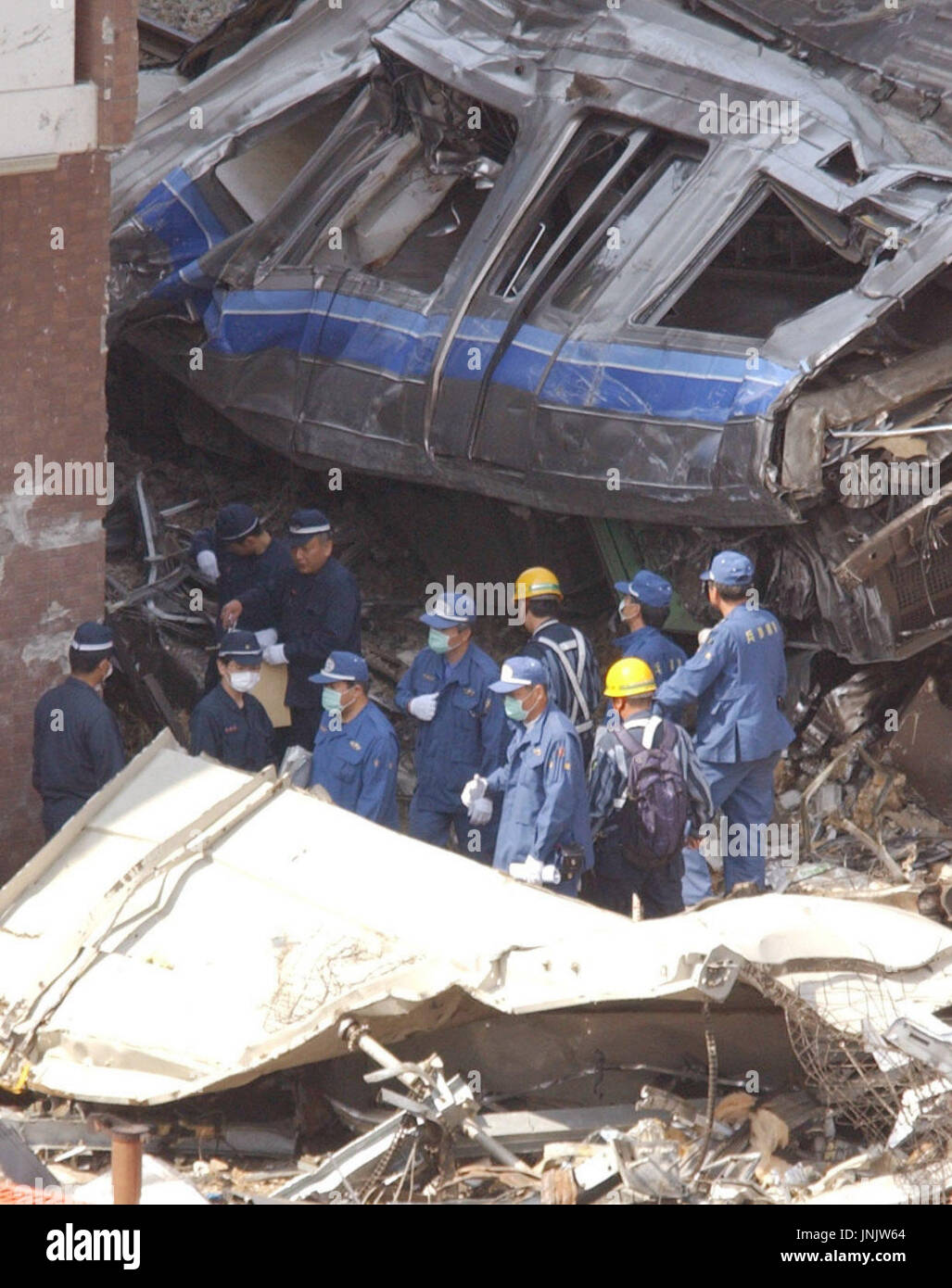 AMAGASAKI, Japan - Police officers investigate a wrecked JR West train in Amagasaki, Hyogo ...
