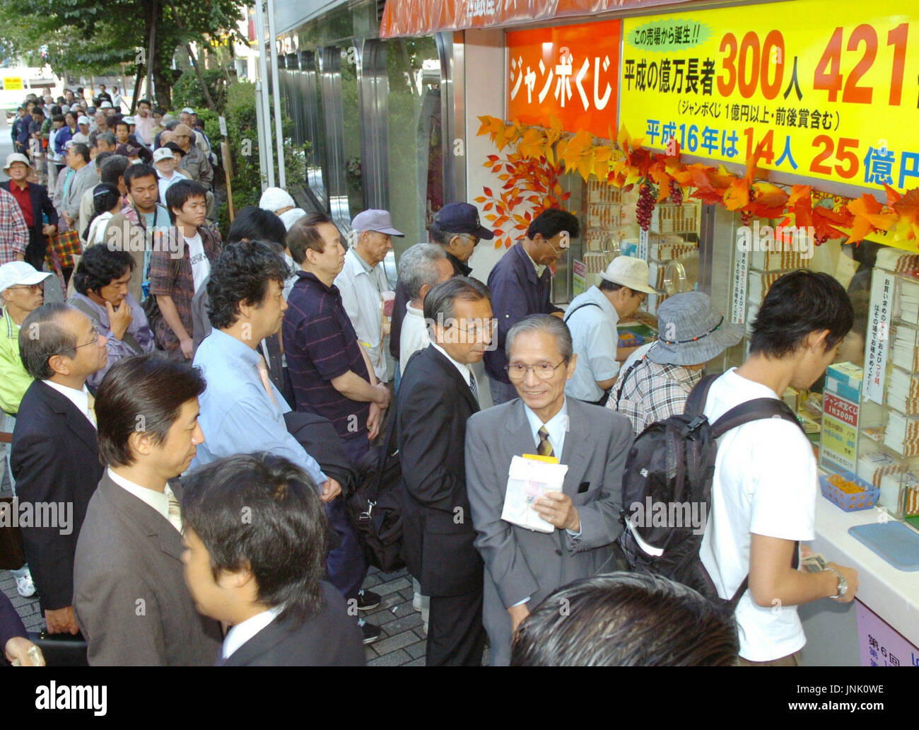 TOKYO, Japan - People line up in front of lottery ticket booths in ...