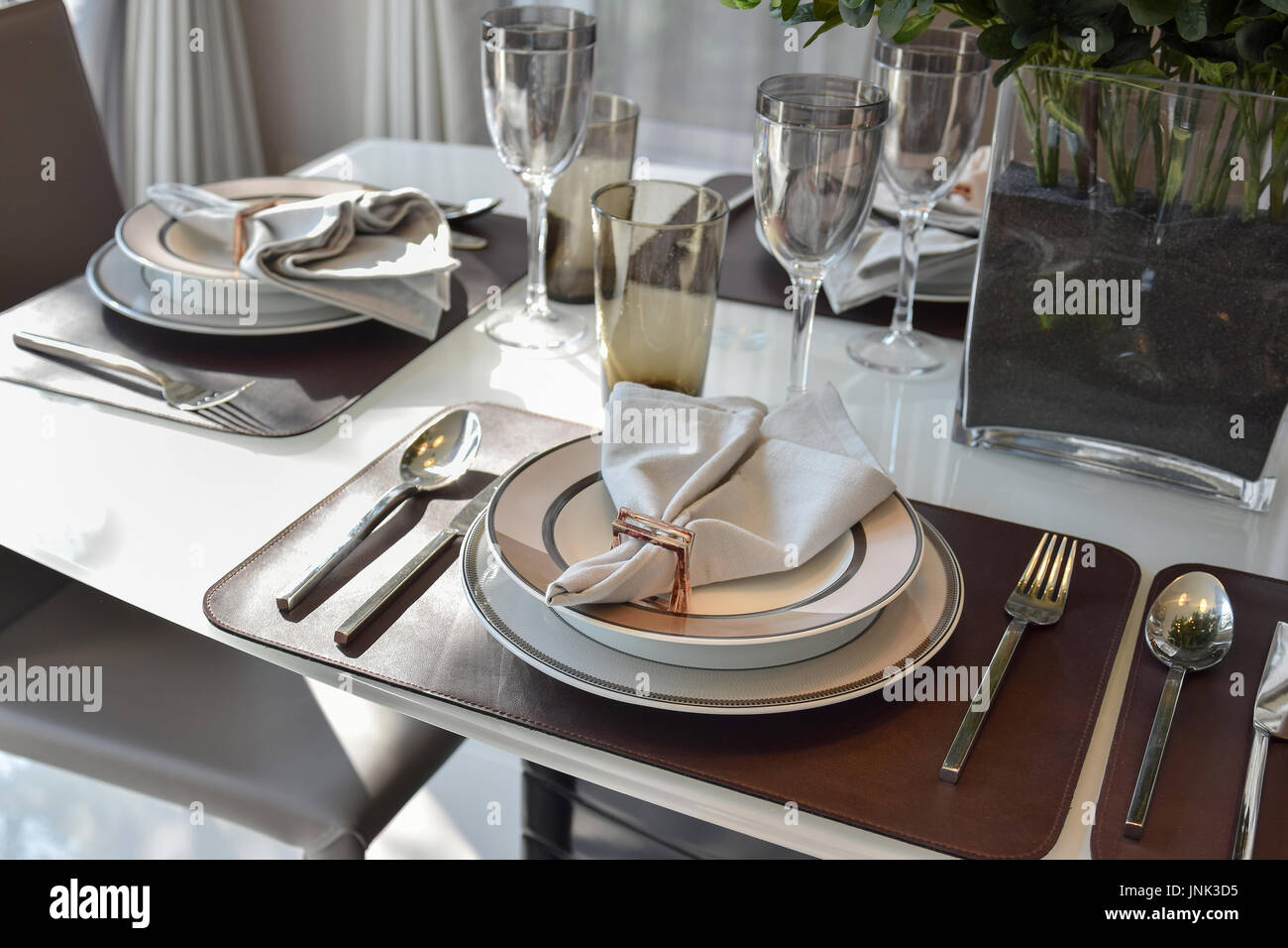 elegant table set in modern style dining room interior Stock Photo - Alamy