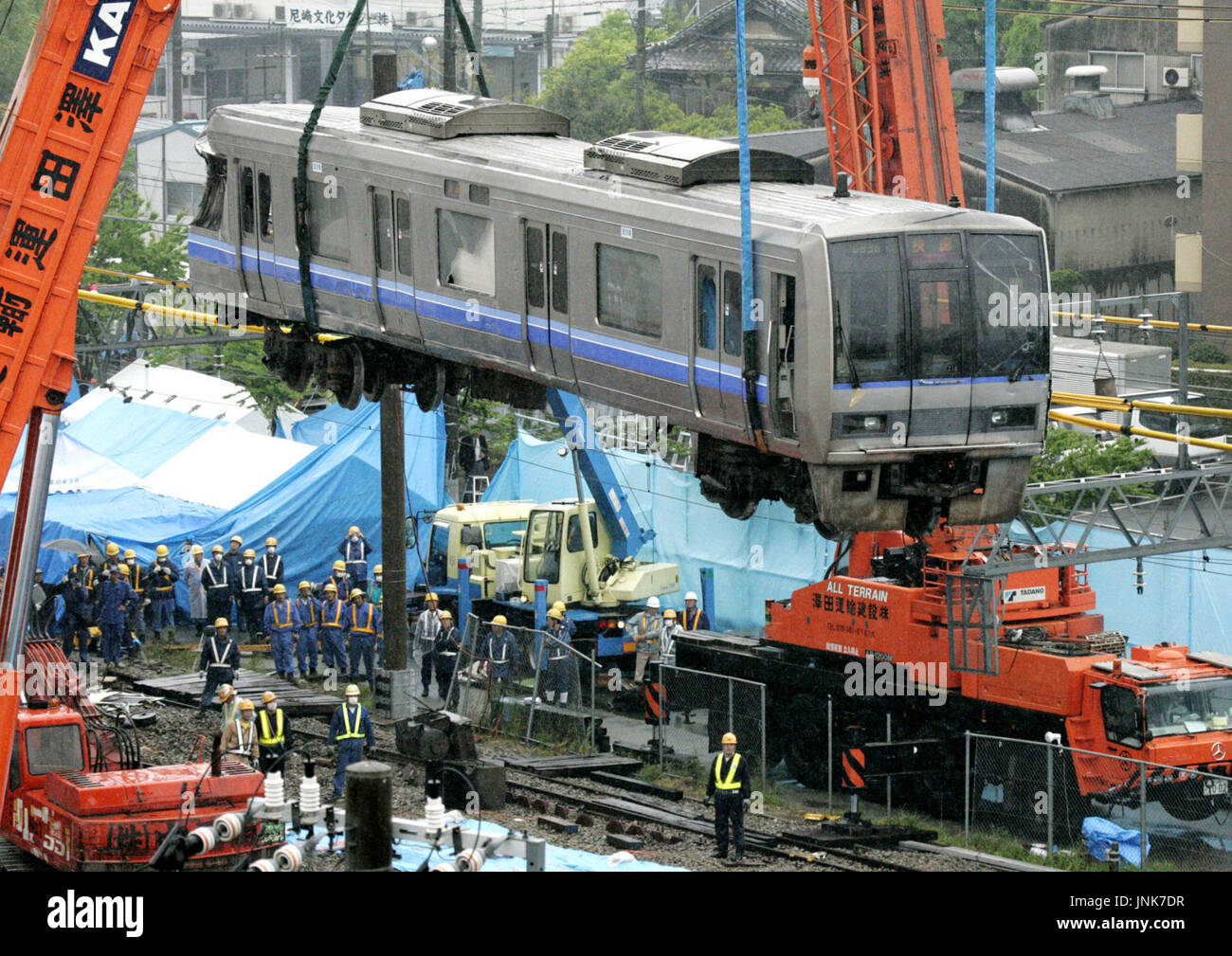AMAGASAKI, Japan - The fourth car of JR West Japan Co.'s derailed seven-car train is hoisted by ...