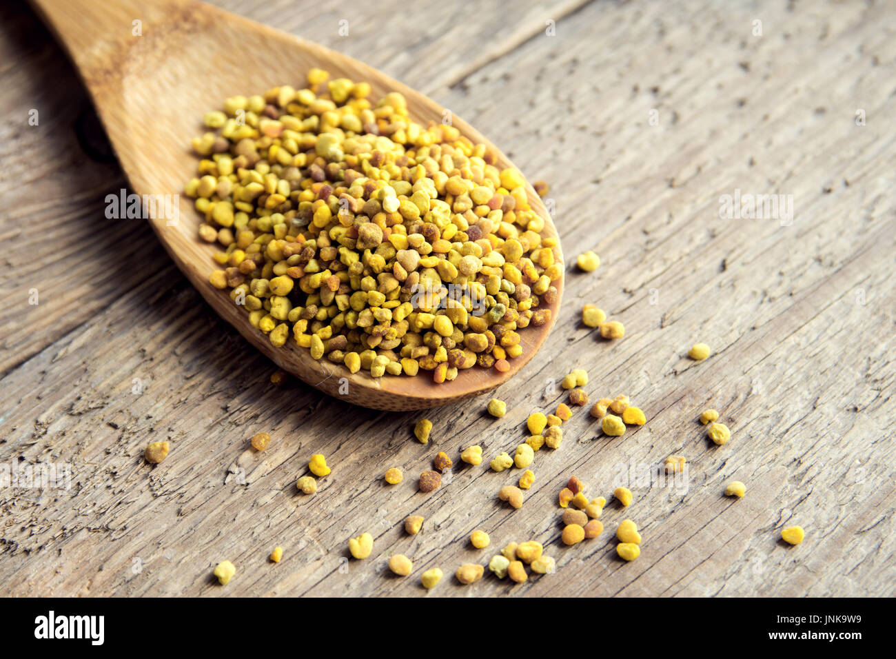 Bee pollen in spoon over wooden background. Healthy organic raw diet ...