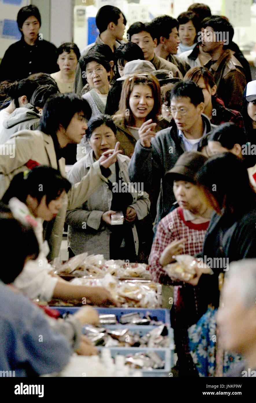 OJIYA, Japan - Local people line up for food at a municipal gymnasium ...