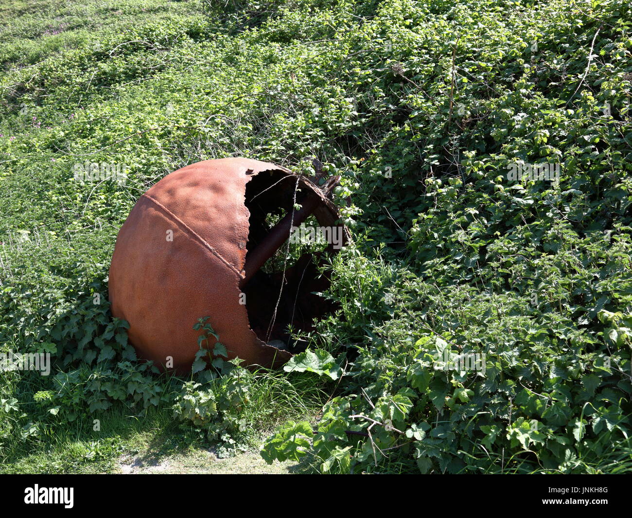 Colourful rusted remains of large steel marine marker / mooring buoy ...