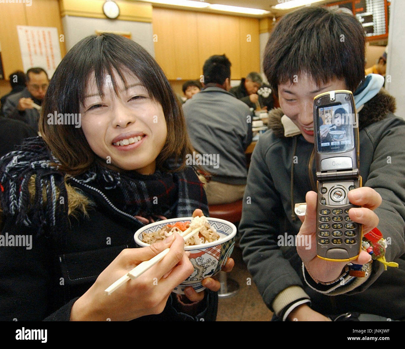 TOKYO, Japan - A woman customer takes a picture of a friend eating a ...