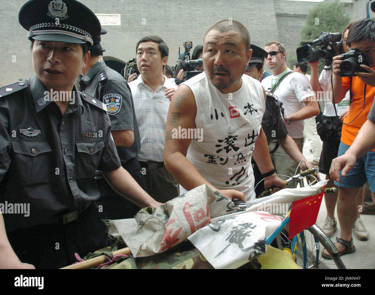 BEIJING, China - Police block a man wearing a shirt emblazoned with ...