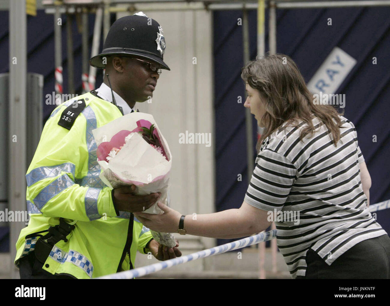 LONDON, Britain - A woman hands a flower bouquet to a police officer in ...