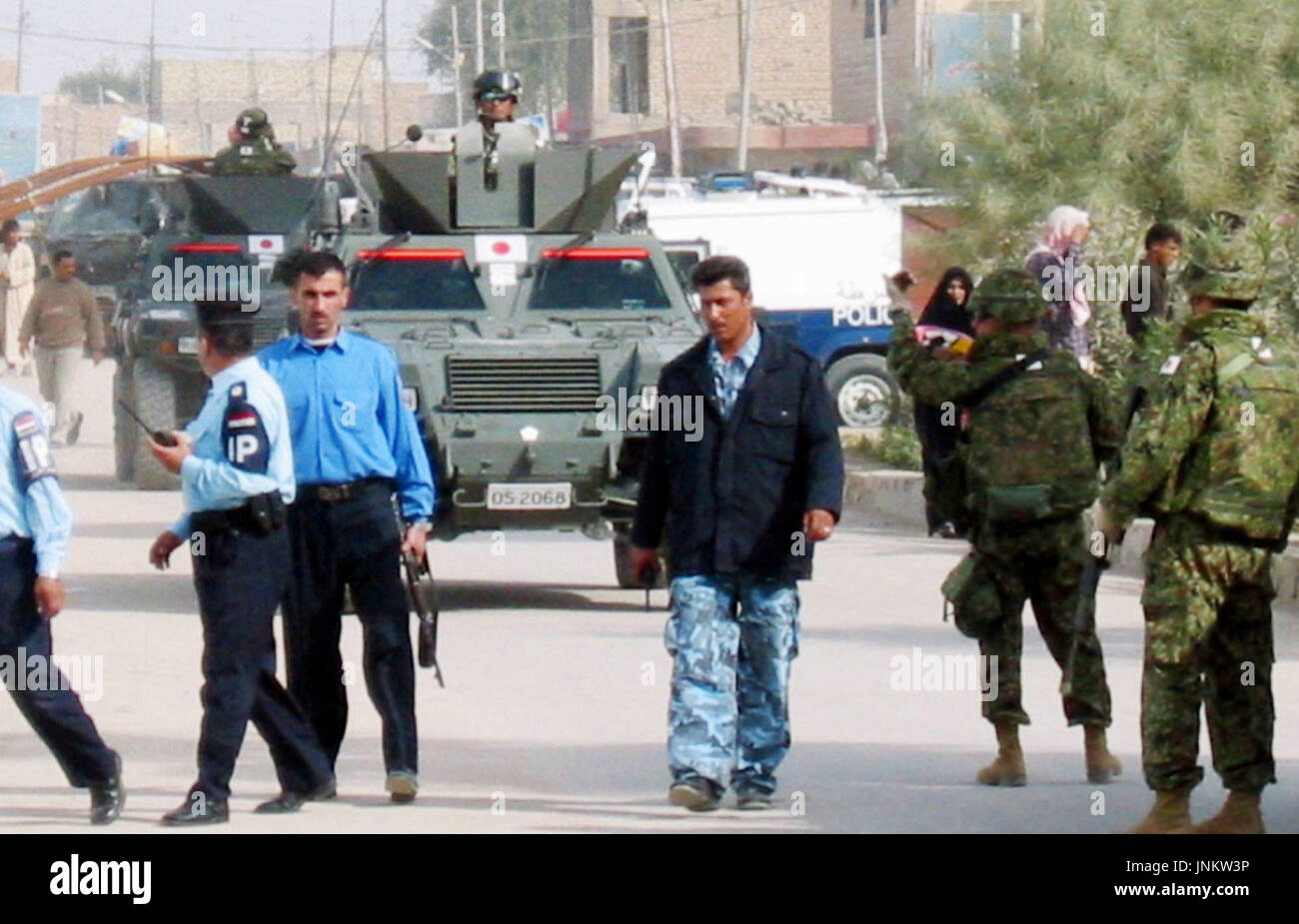 SAMAWAH, Iraq - Policemen guard Japanese troop vehicles in Rumaythah ...