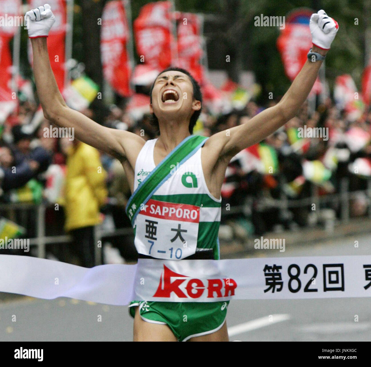 TOKYO, Japan - Asia University's ''ekiden'' road relay team anchor, Naohiro Okada, breaks the ...