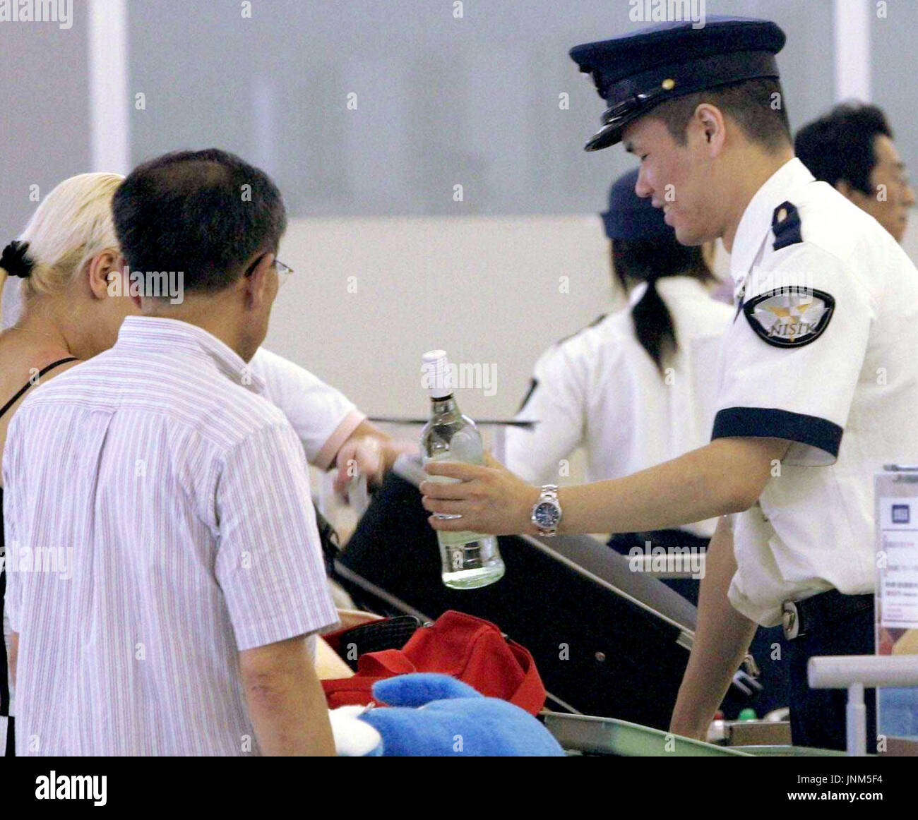 OSAKA, Japan - An airport officer takes out a beverage bottle from a ...
