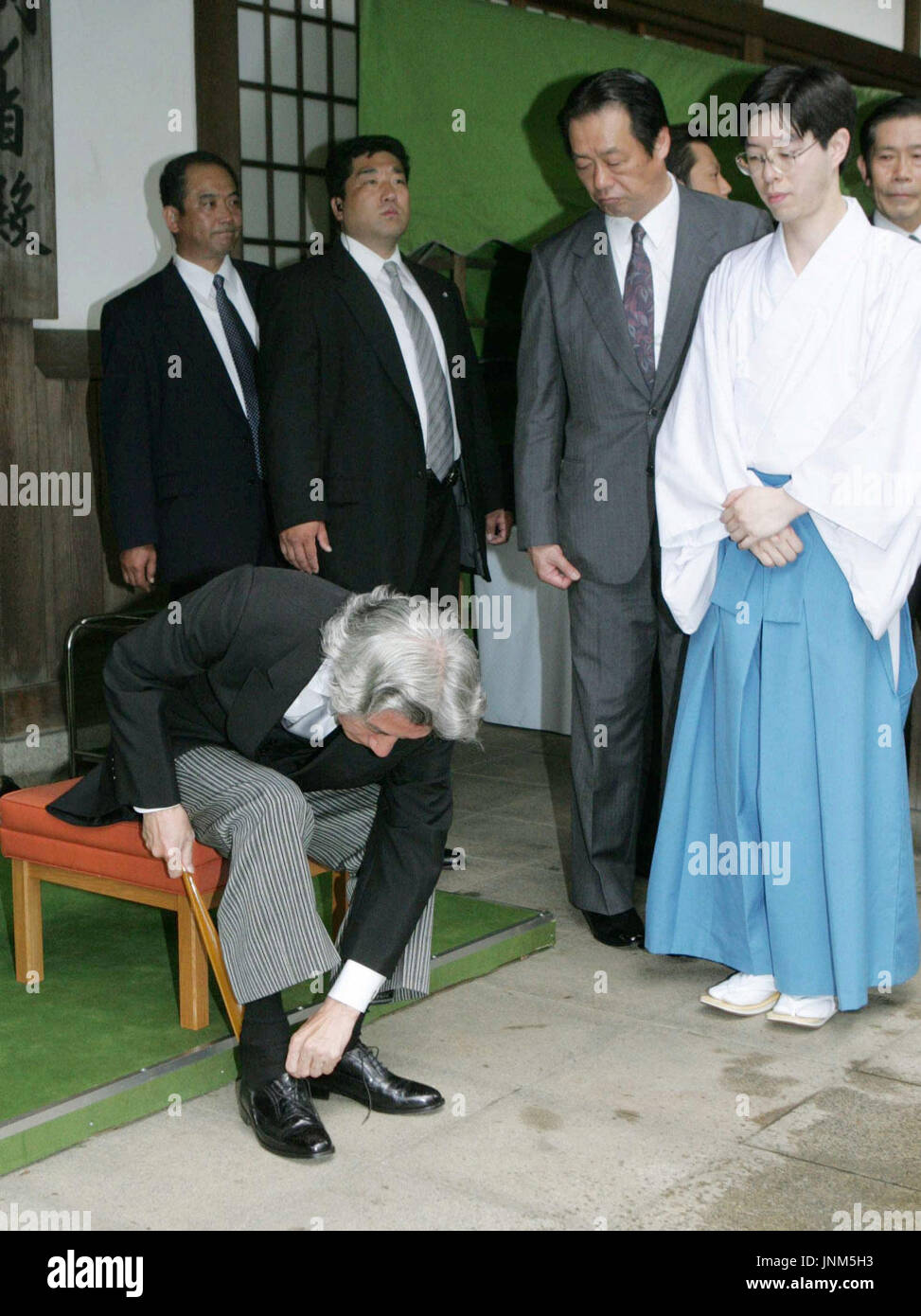 TOKYO, Japan - Prime Minister Junichiro Koizumi puts on his shoes after ...