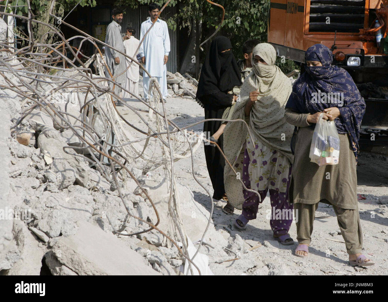 GARHI HABIBULLAH KHAN, Pakistan - Villagers stand by the debris of a ...
