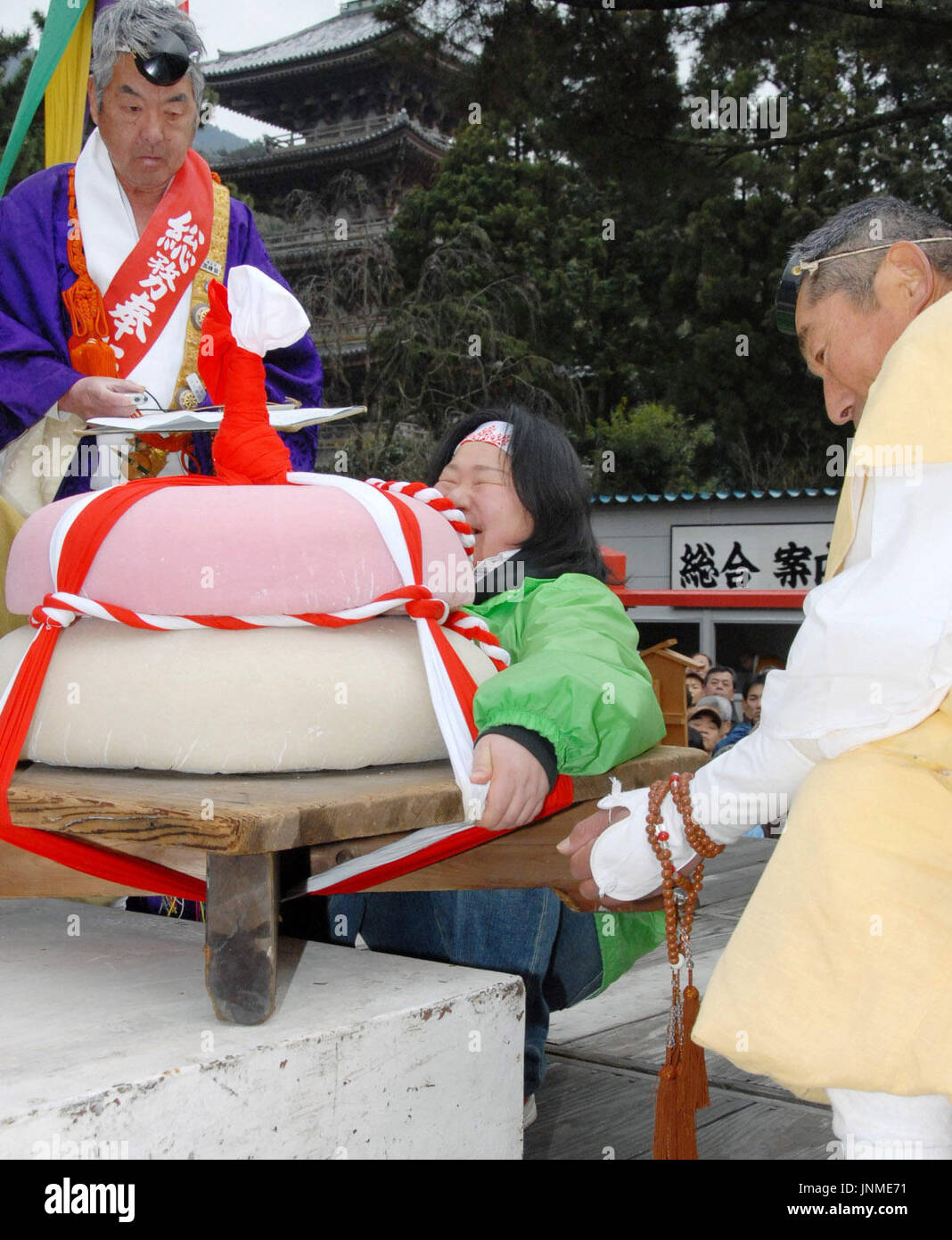 KOTO, Japan - A woman tries to lift 90-kilogram rice cakes during an ...