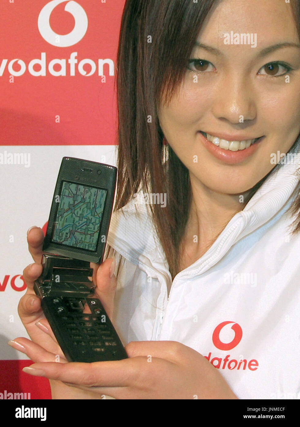 TOKYO, Japan - A model holds up Vodafone K.K.'s new mobile phone 904SH model by Sharp Corp ...