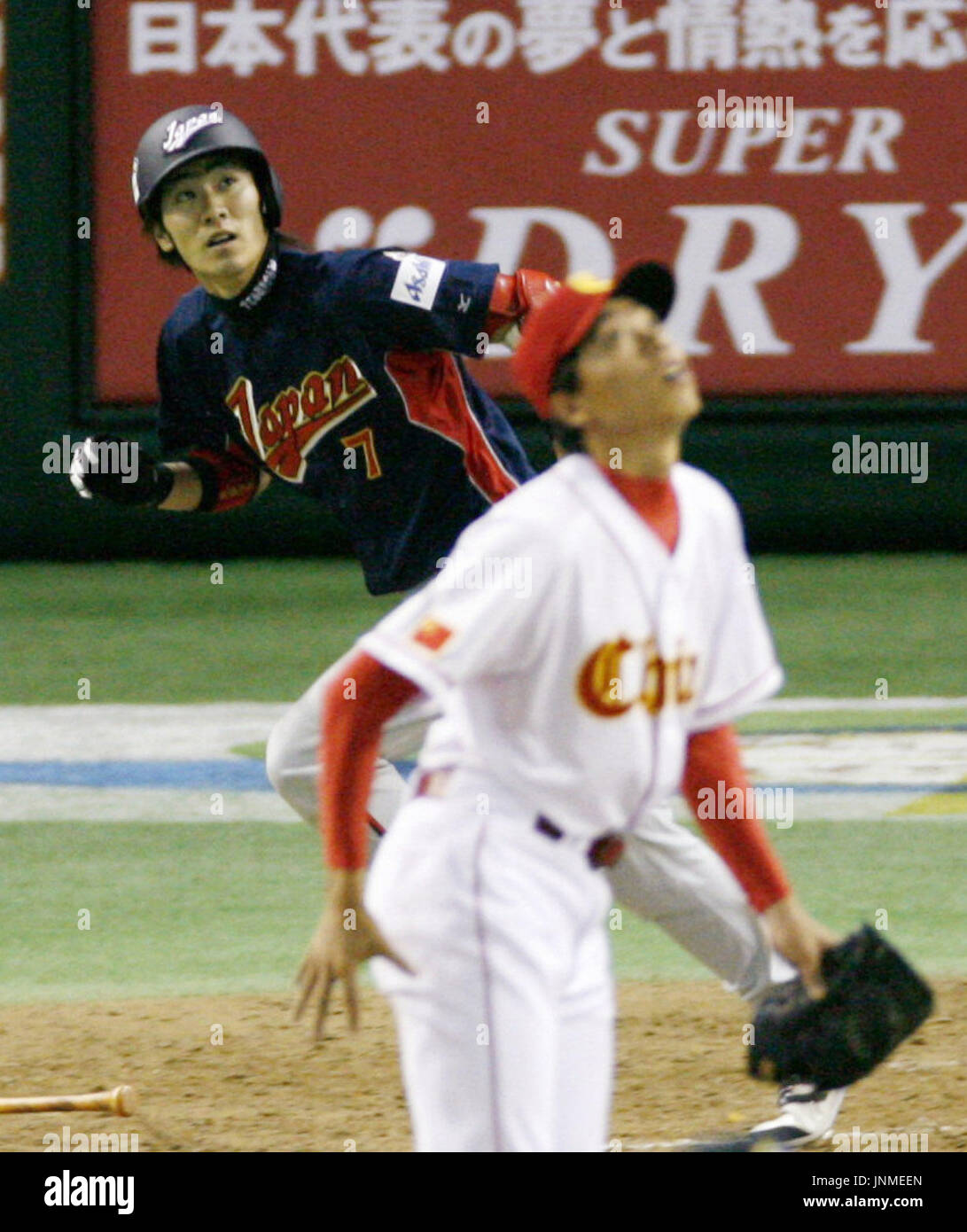TOKYO, Japan - Japanese infielder Tsuyoshi Nishioka (back) hits a three ...