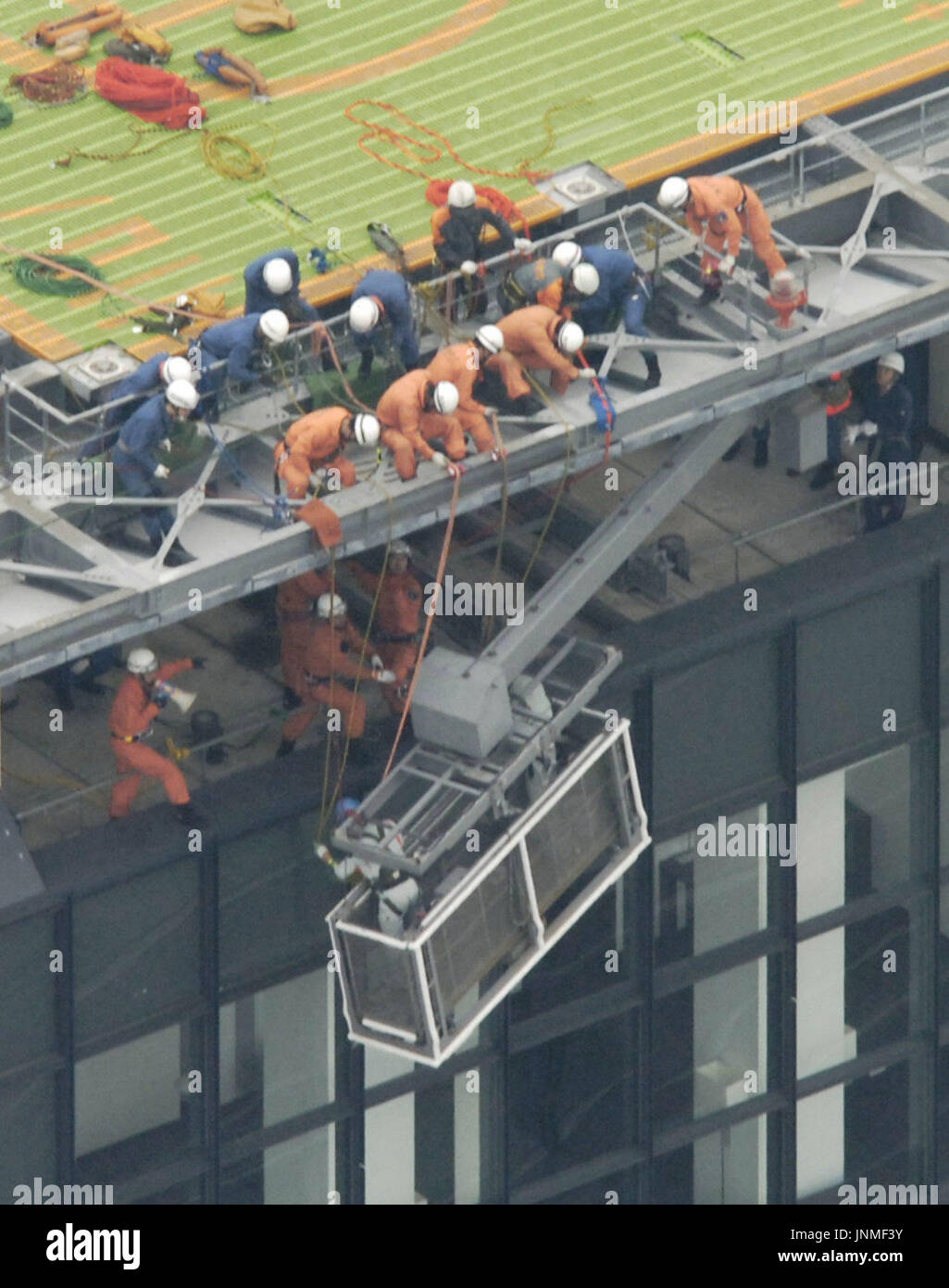 TOKYO, Japan - Rescuers try to rescue two window cleaners from a ...