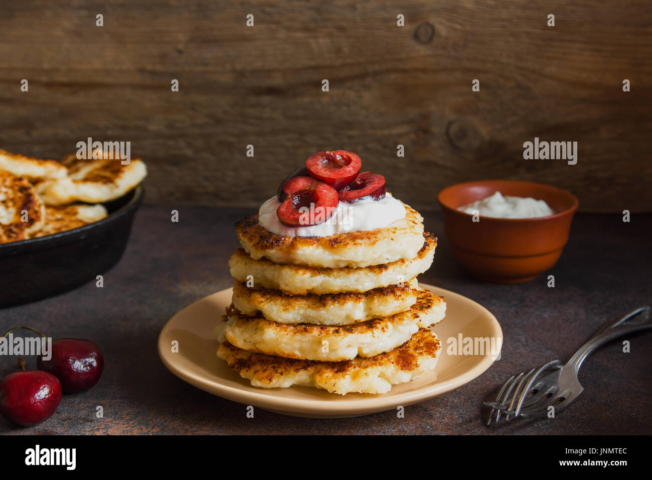 Rustic homemade curd pancakes with yogurt sauce and cherry for ...