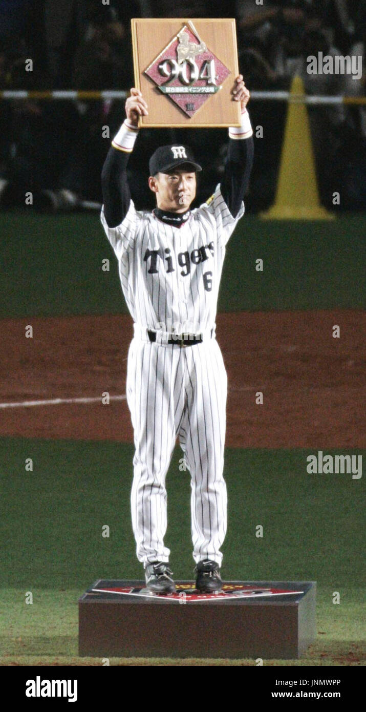 OSAKA, Japan - Hanshin Tigers' cleanup hitter Tomoaki Kanemoto holds up a memorial plate given ...