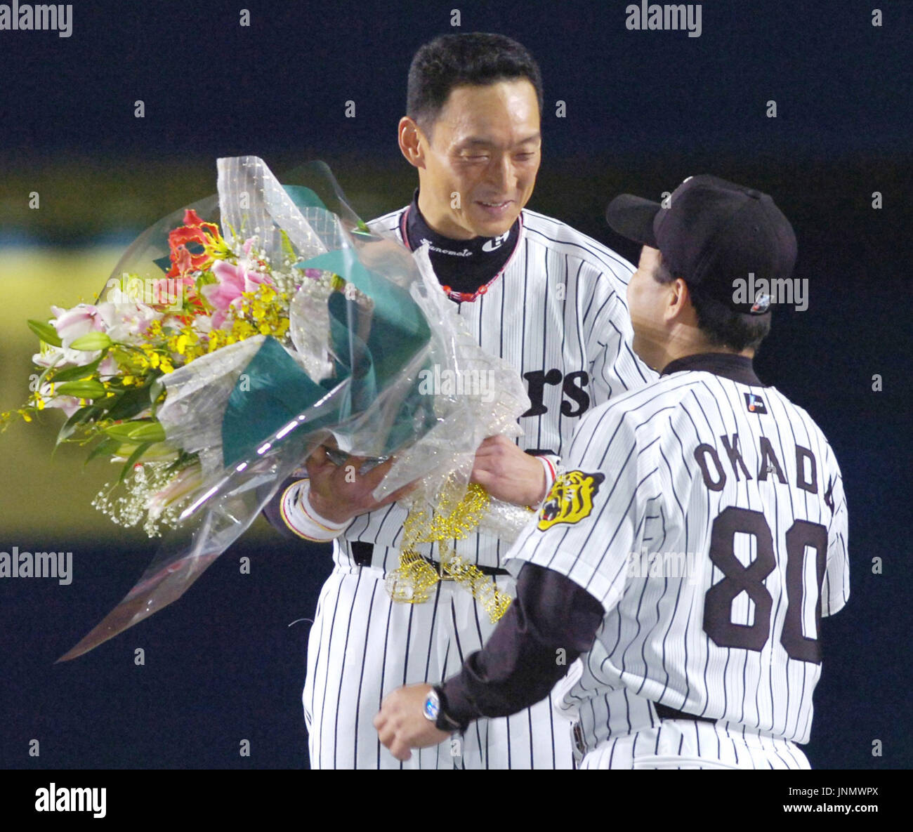 OSAKA, Japan - Hanshin Tigers' cleanup hitter Tomoaki Kanemoto is celebrated by team manager ...