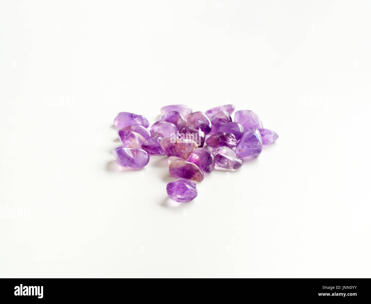 Tumbled Amethyst stones close up on table for crystal therapy ...