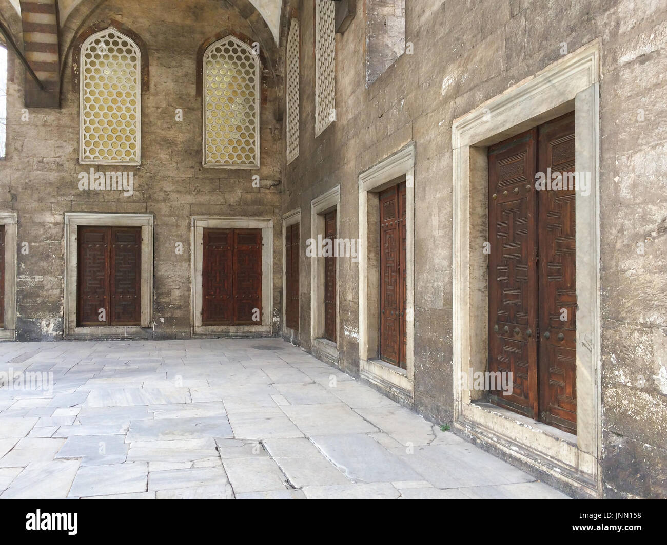 Portico with doors in a row and grids in the courtyard of an ancient ...