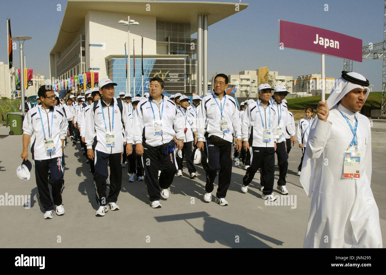 DOHA, Qatar - Japanese delegates to the Asian Games walk into the ...