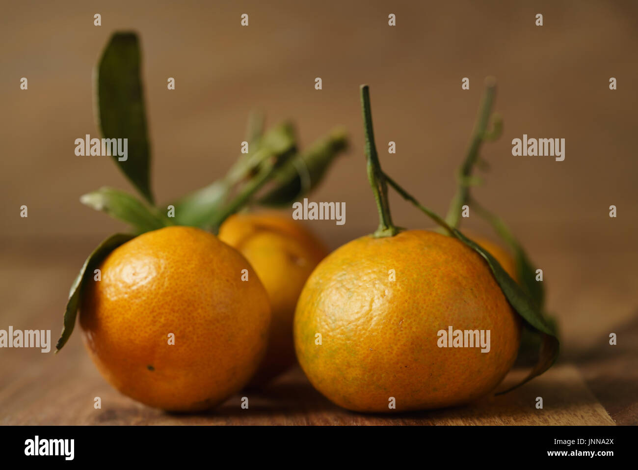 organic tangerines with leaves on wood table Stock Photo - Alamy