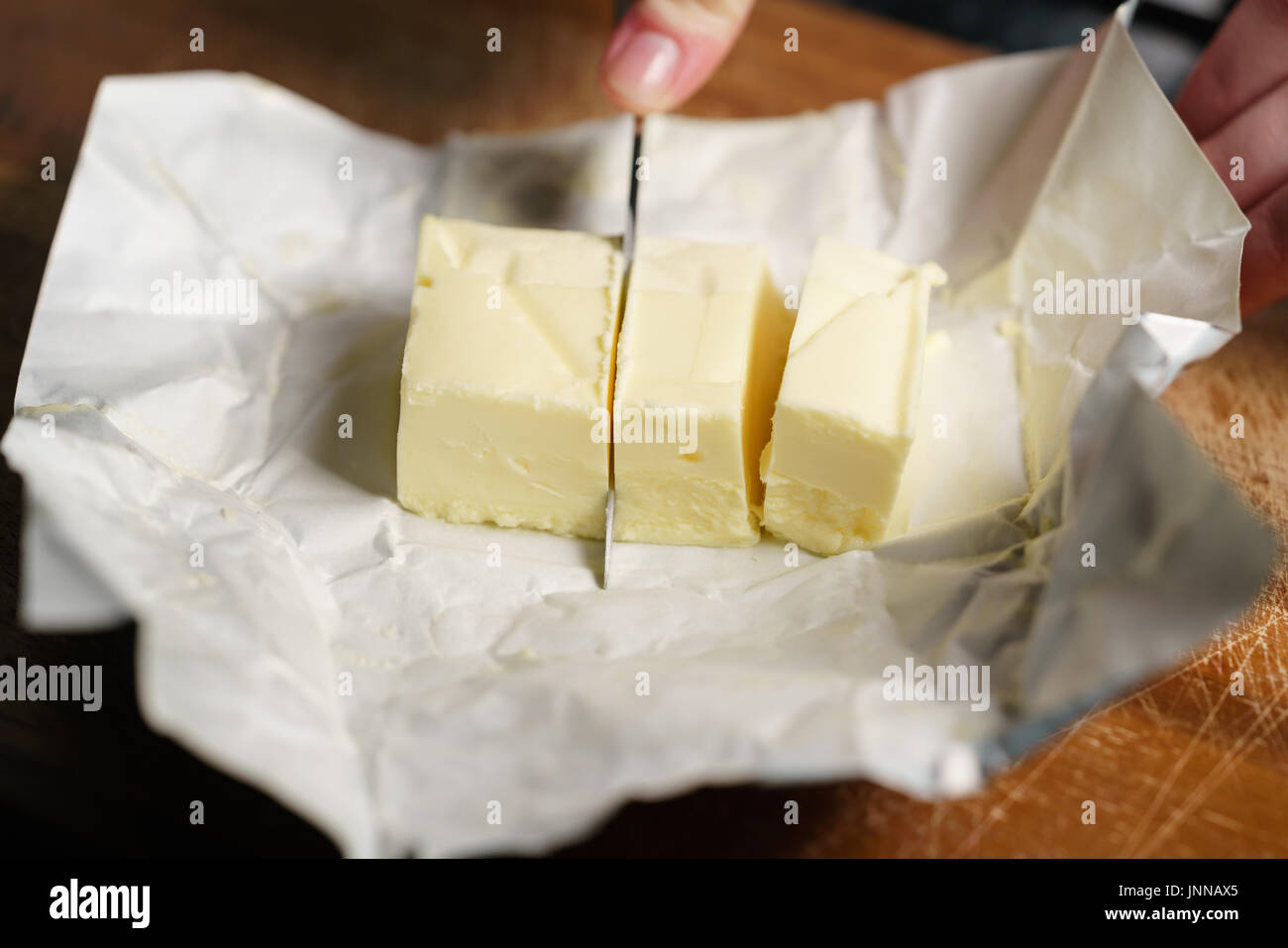 slicing butter brick with knife Stock Photo - Alamy
