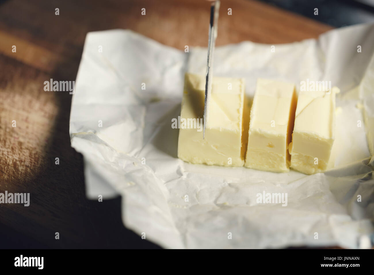 slicing butter brick with knife Stock Photo - Alamy