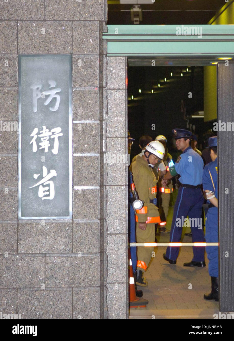 TOKYO, Japan - Police officers and firefighters examine the area near ...