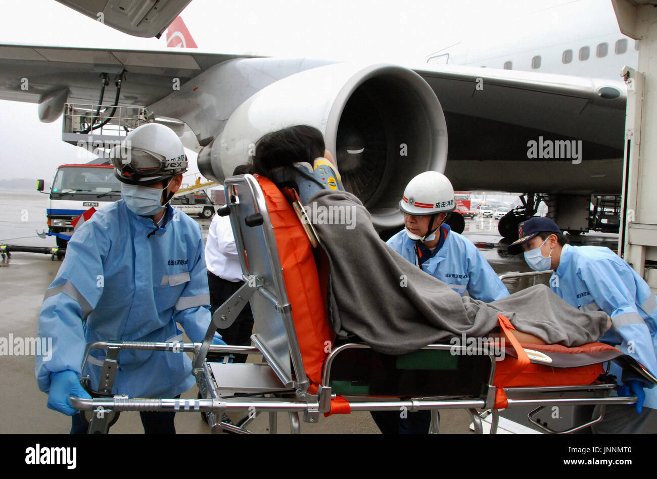 NARITA, Japan - Emergency workers transport an injured passenger on a ...