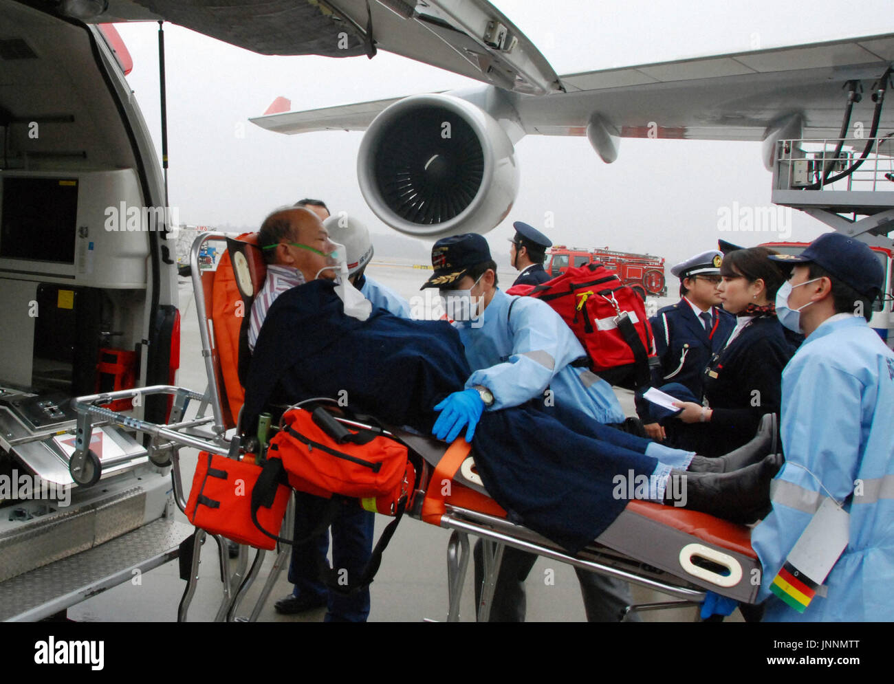 NARITA, Japan - Emergency workers transport an injured passenger on a ...