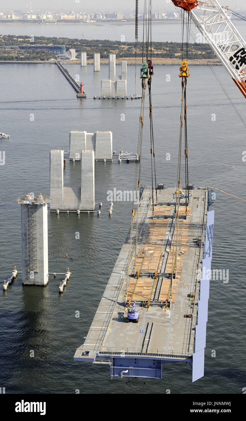 TOKYO, Japan - A bridge section is lifted onto columns in Tokyo Bay on ...