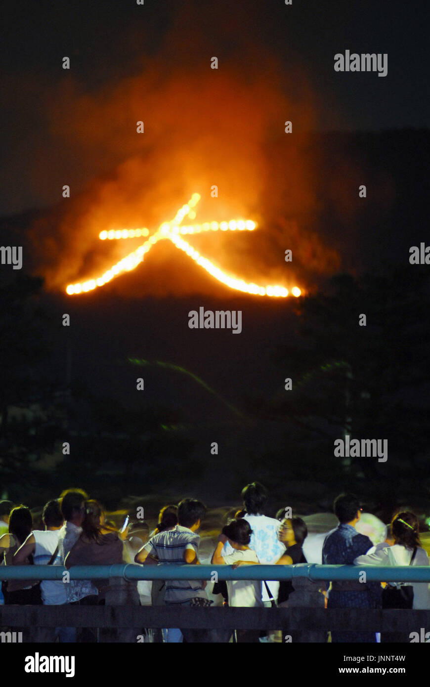 KYOTO, Japan - Locals and tourists enjoy viewing a giant bonfire in the ...